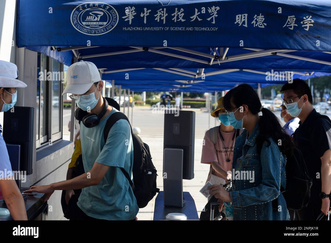 College students pass the health check at the gate to the campus of a ...