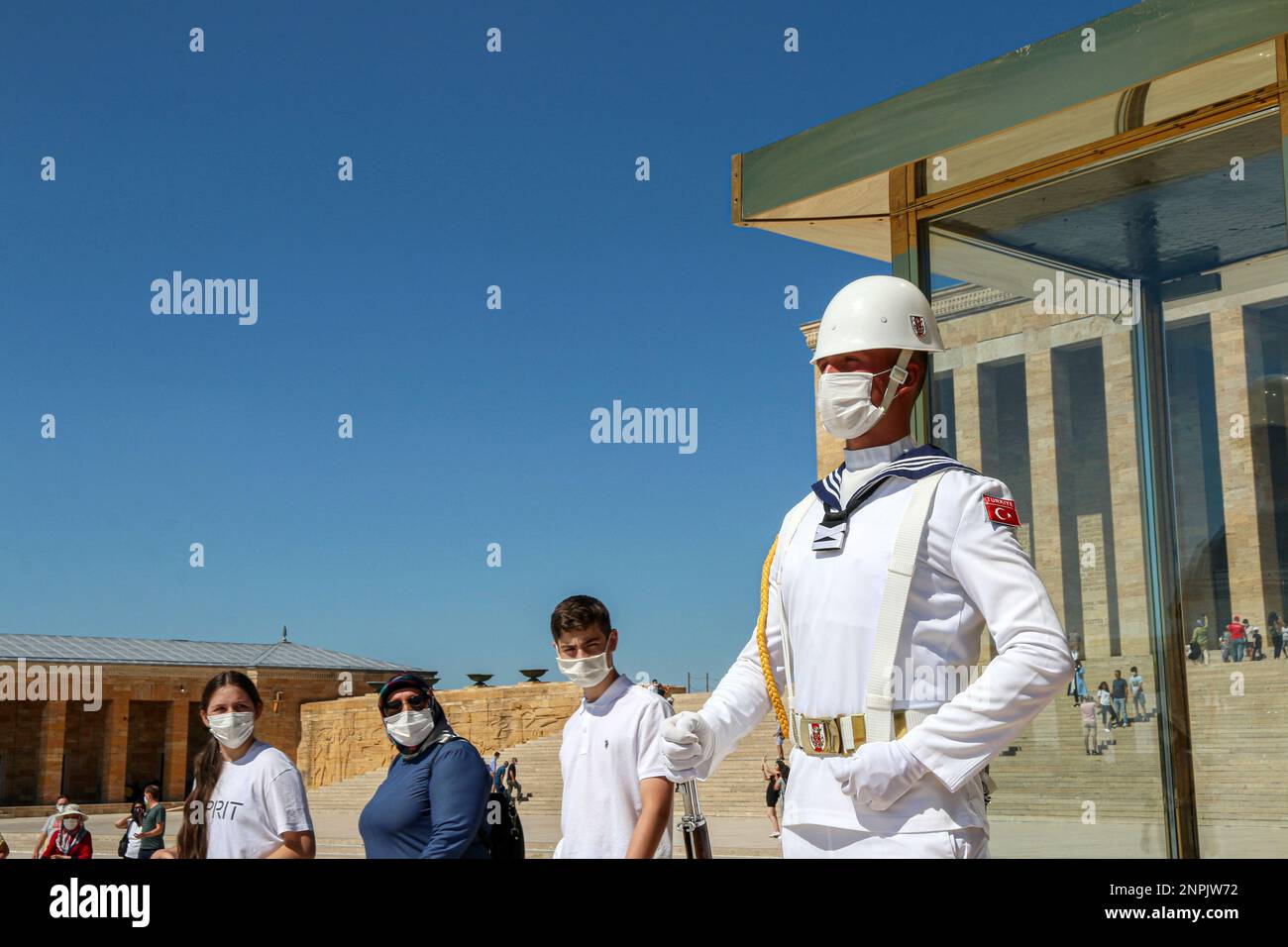 A Turkish soldier wearing a protective face mask stands guard at ...