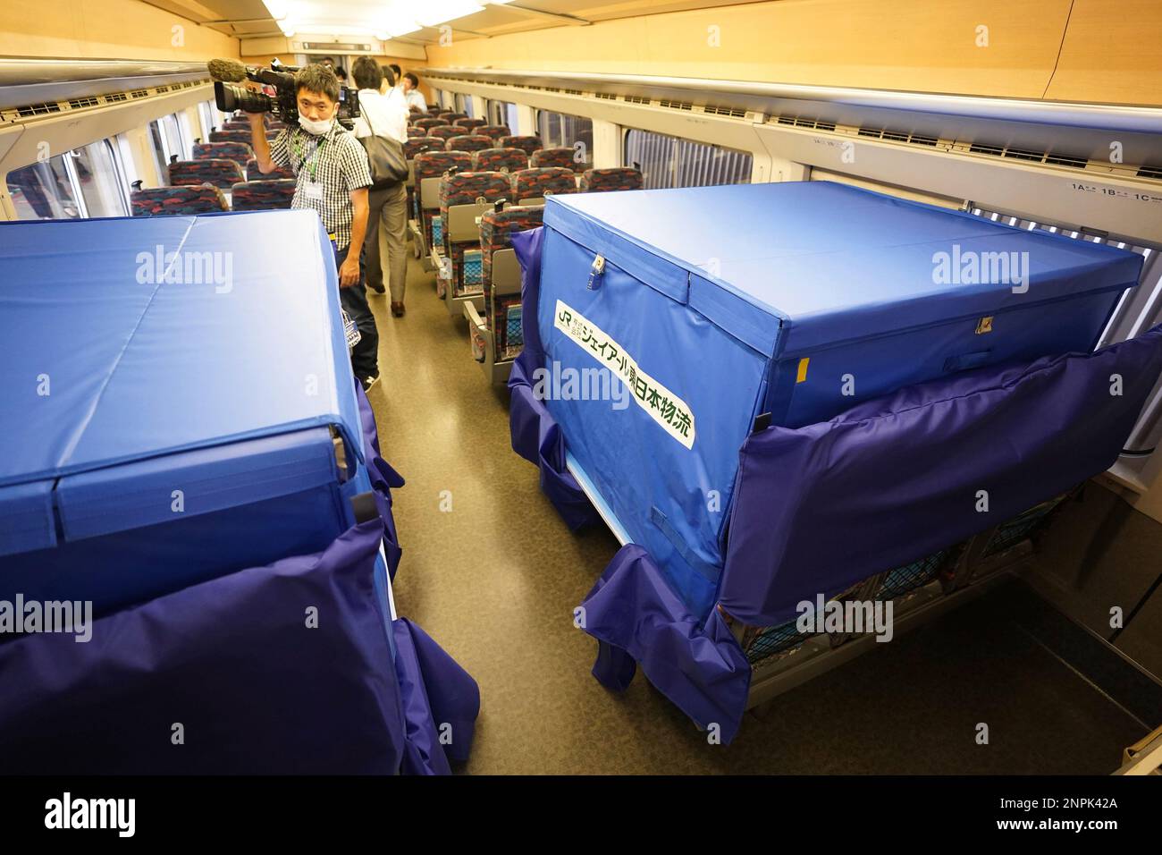 Workers carry fish in boxes into Tohoku Shinkansen bullet train at ...