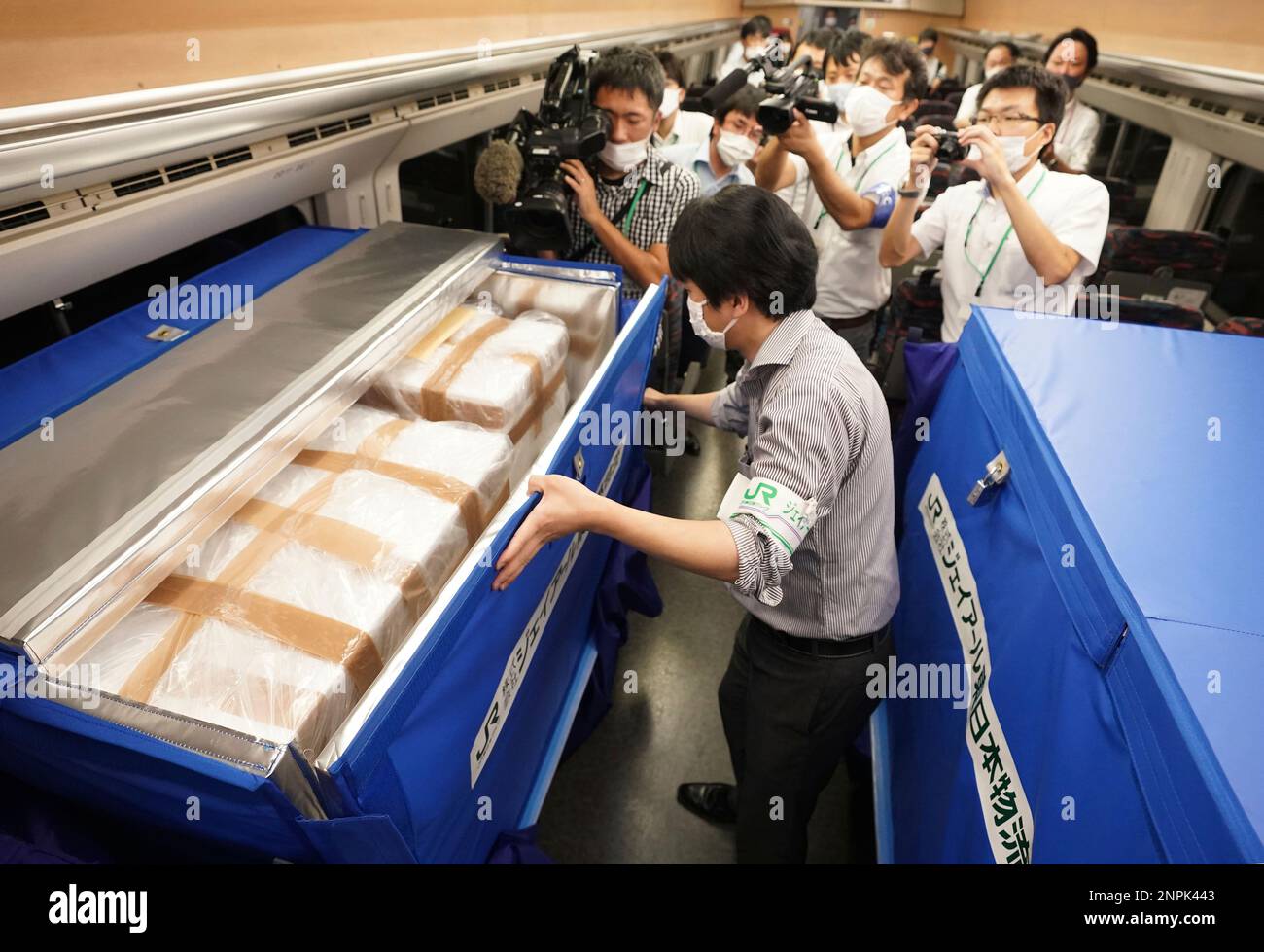 Workers carry fish in boxes into Tohoku Shinkansen bullet train at ...