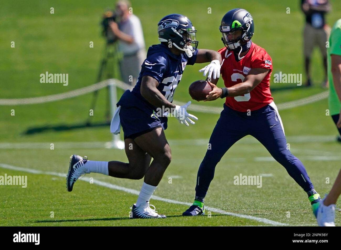 Seattle Seahawks quarterback Russell Wilson hands off to running back ...
