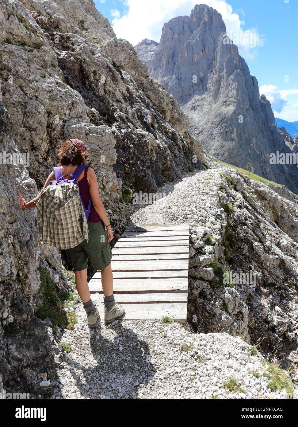 young woman walks on the trail of european alps dolomites on the wooden ...
