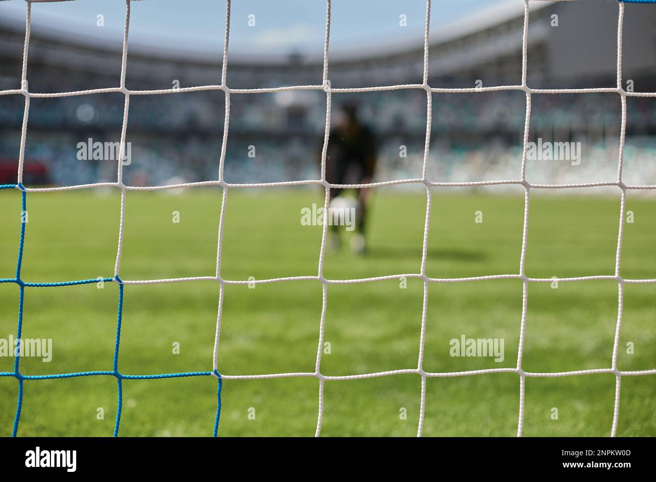Young african american man holding soccer ball against soccer goal net ...