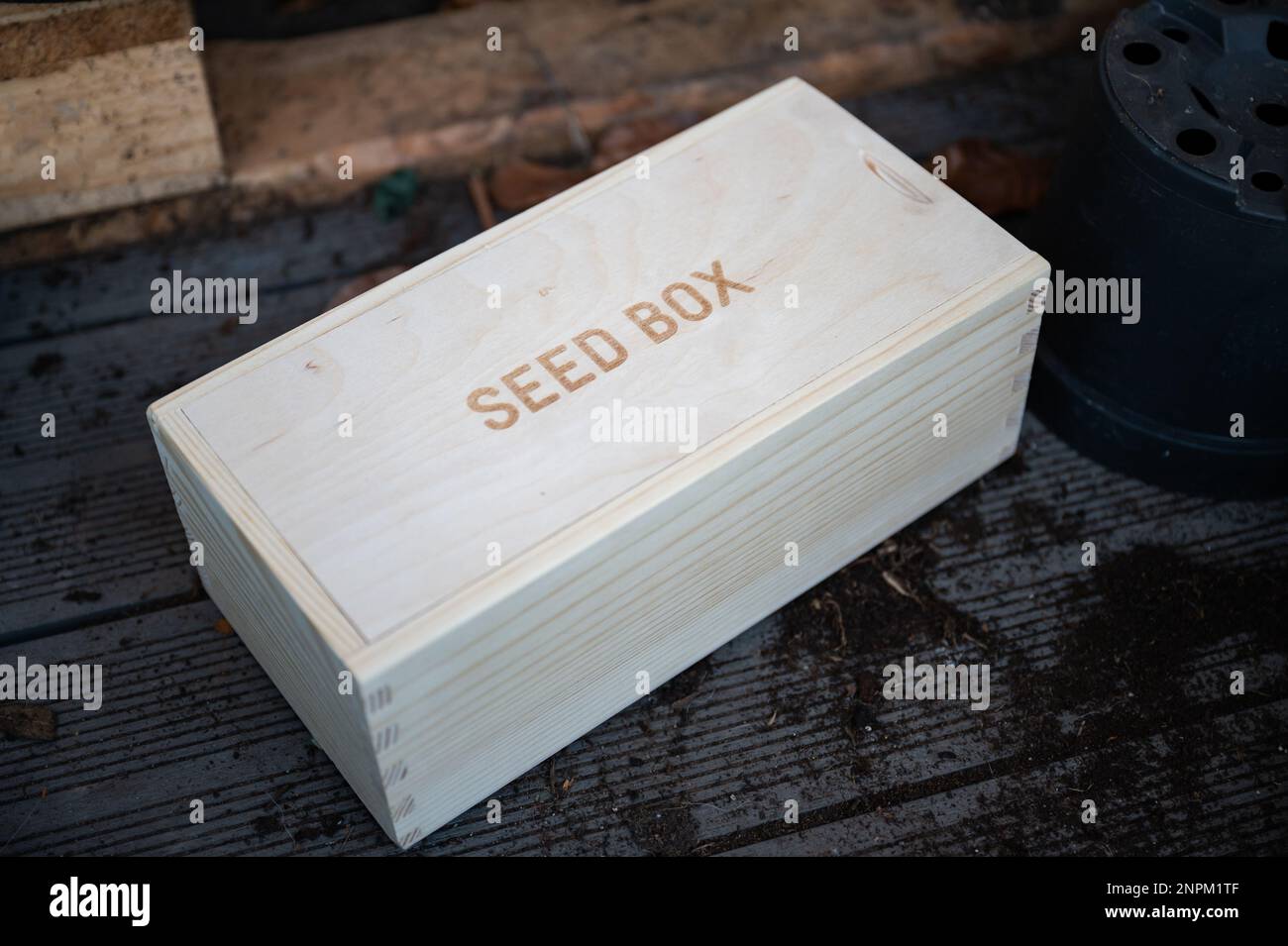 Close-up wooden Seed Box standing on the balcony ground with soil and ...