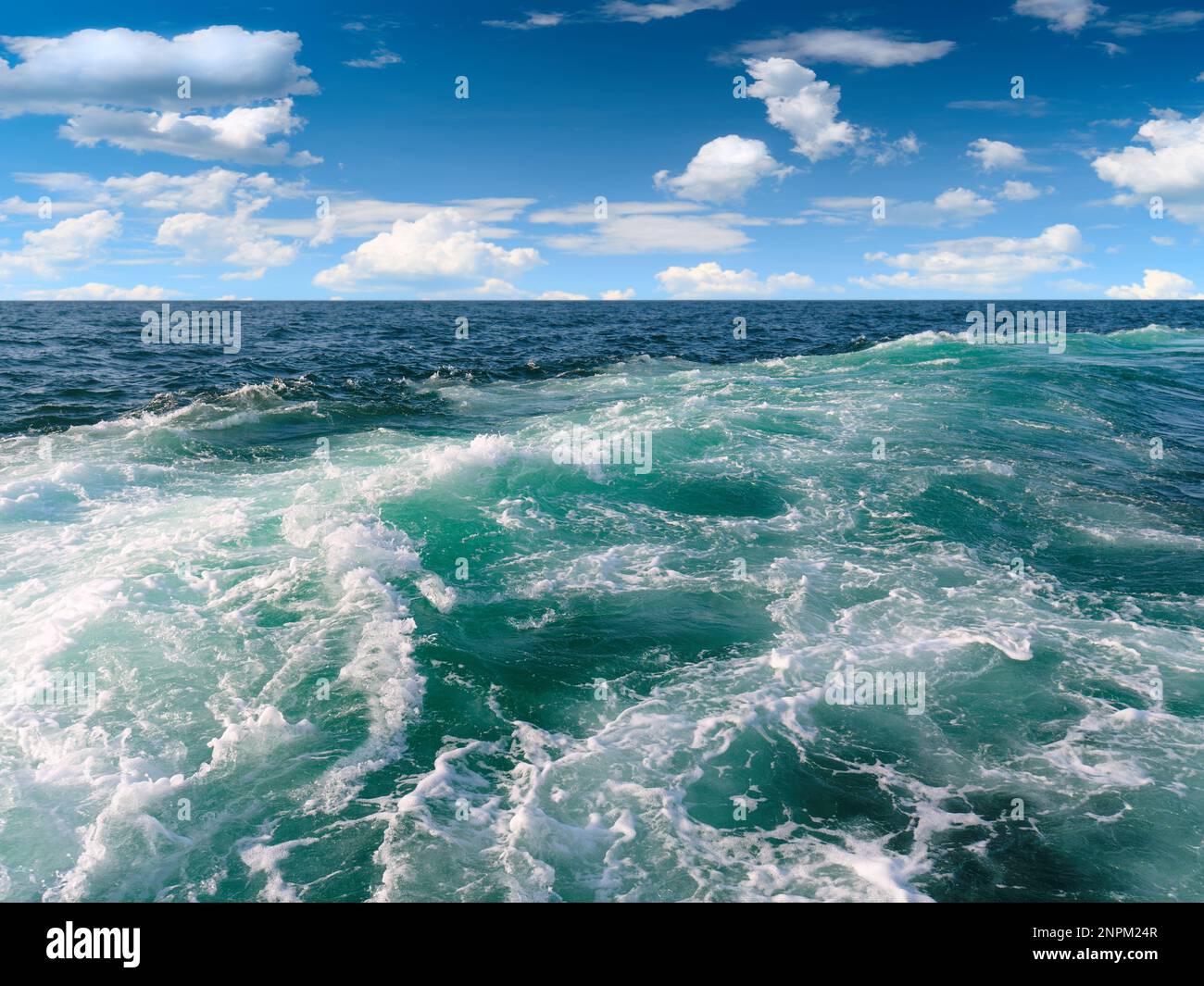 View of sea surface and sky with clouds. Wake stream from the ship ...