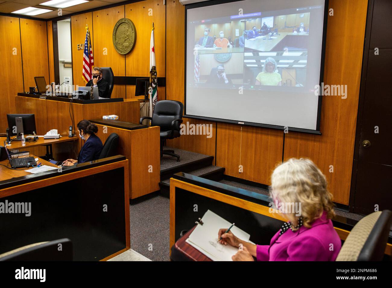 Peggy Frink, in fourth quadrant on the screen, reads a statement at the ...