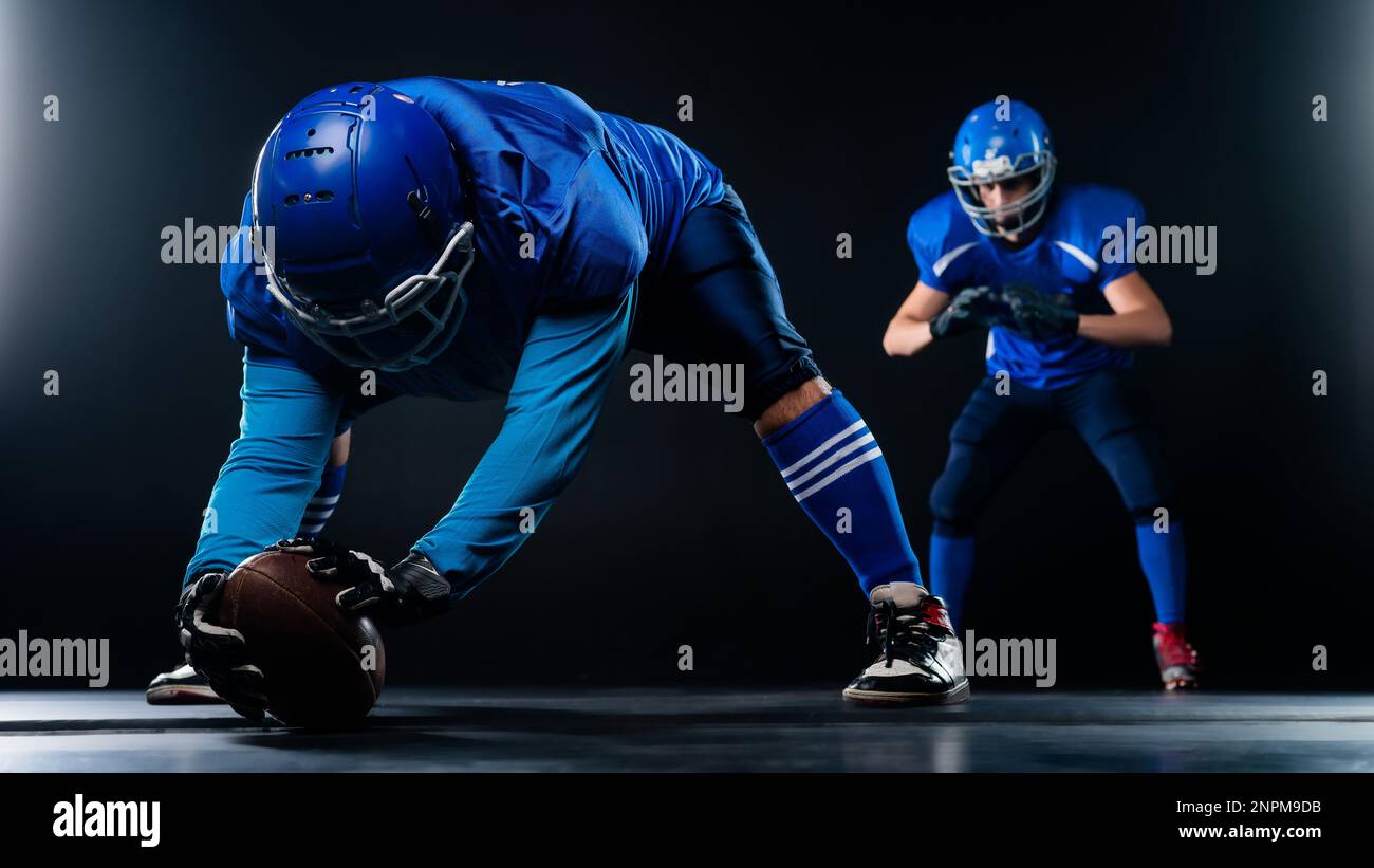 Two American football players are ready to start the game on a black ...