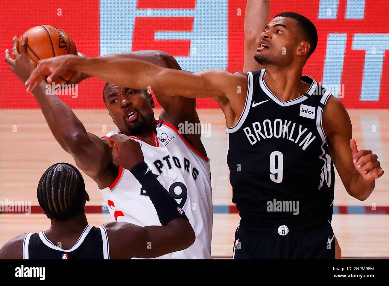 Toronto Raptors' Serge Ibaka, center, grabs a rebound against Brooklyn ...