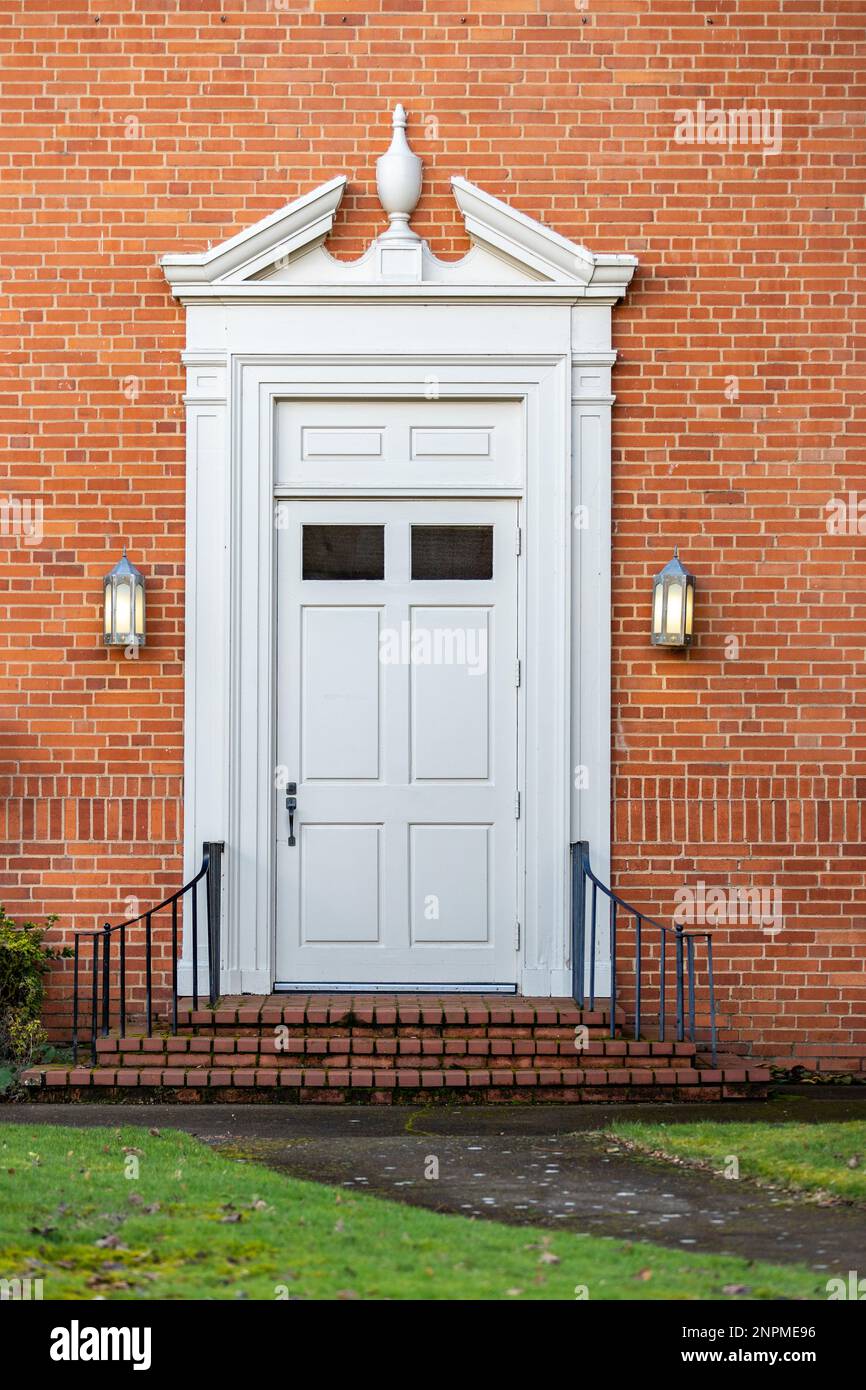 White doorway entry with lights on both sides on the side of an old ...