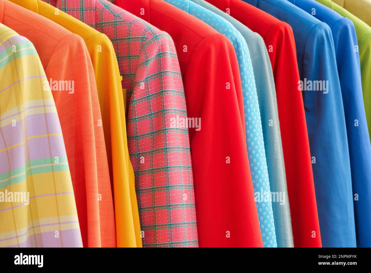 Fashion clothes on clothing rack - bright colorful closet. Closeup of ...