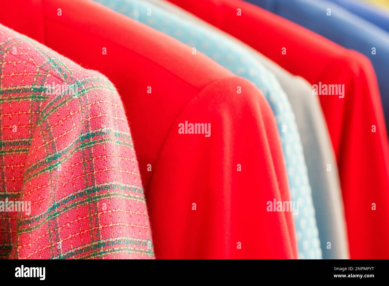 Fashion clothes on clothing rack - bright colorful closet. Closeup of ...