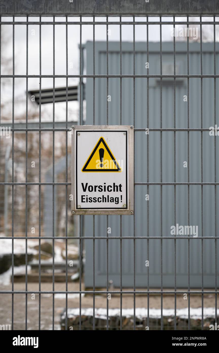 Close-up german warning sign caution icefall installed at a fence at an ...