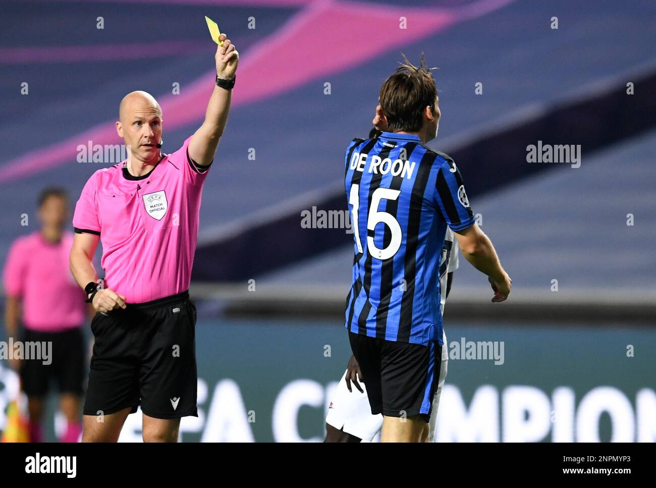 Referee Anthony Taylor shows a yellow card to Atalanta's Marten de Roon ...