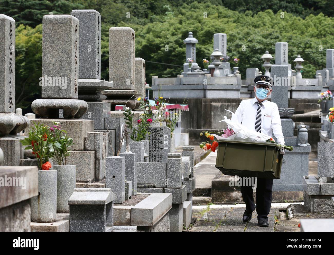 A taxi driver visits to clean a grave and lays offerings at the ...