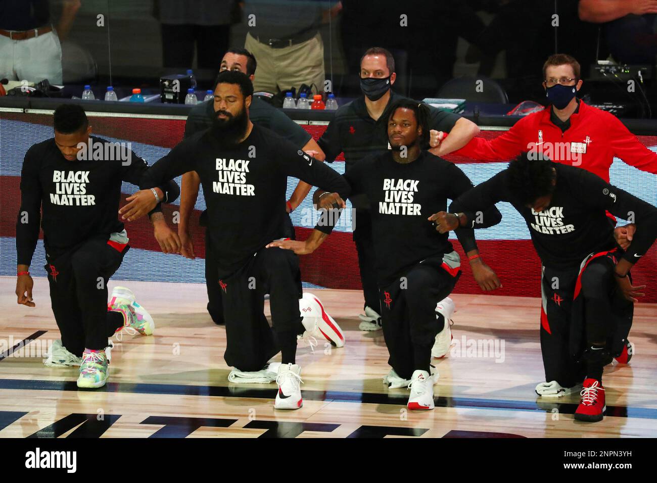 Houston Rockets team members kneel before an NBA basketball game ...