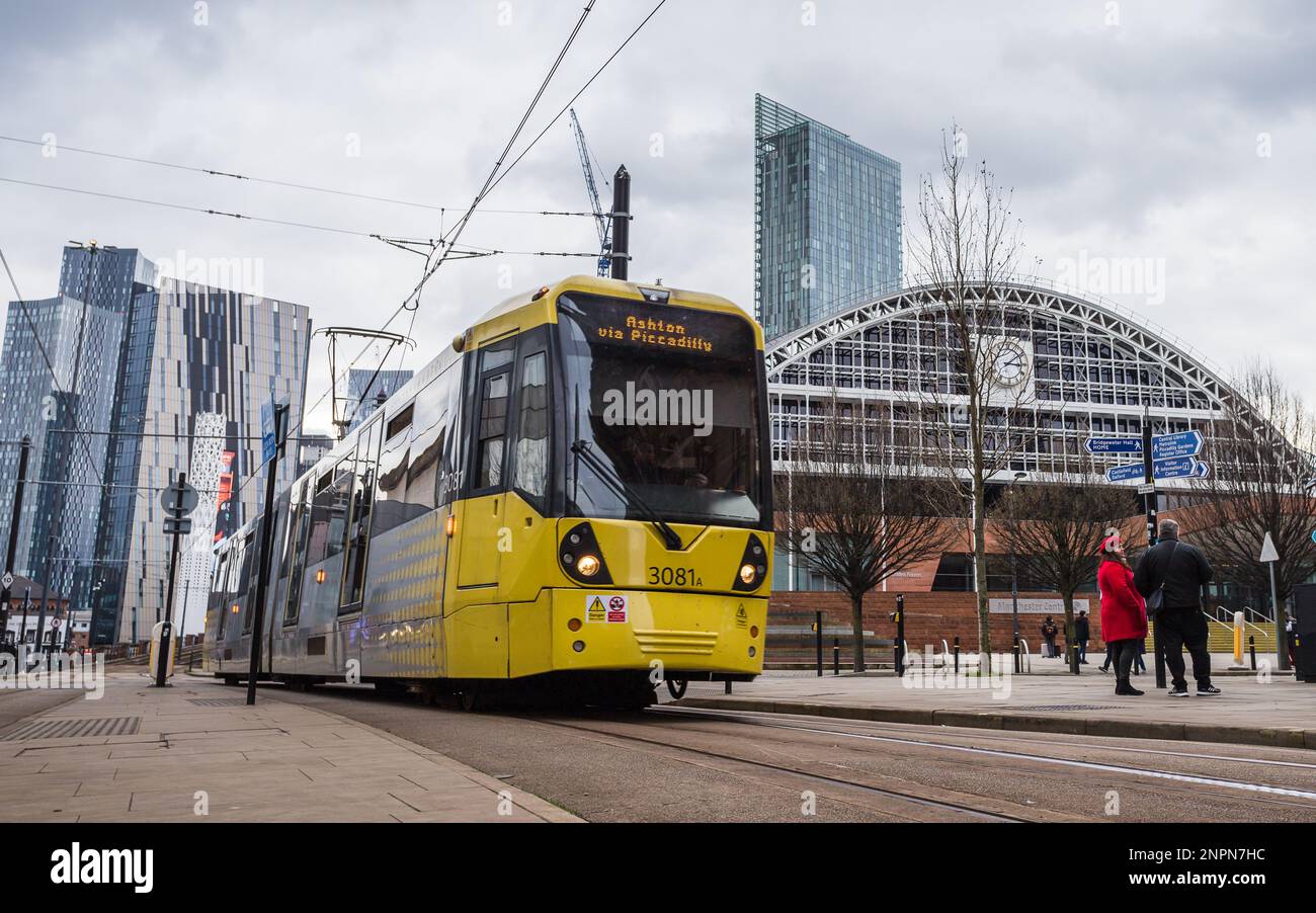 A yellow Metrolink tram passes the Manchester Central Convention ...