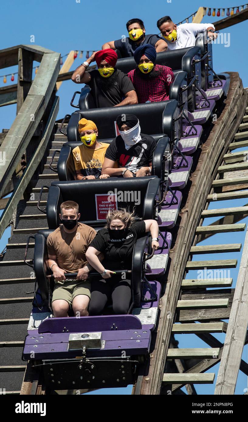 People wear face masks while riding the wooden roller coaster at ...