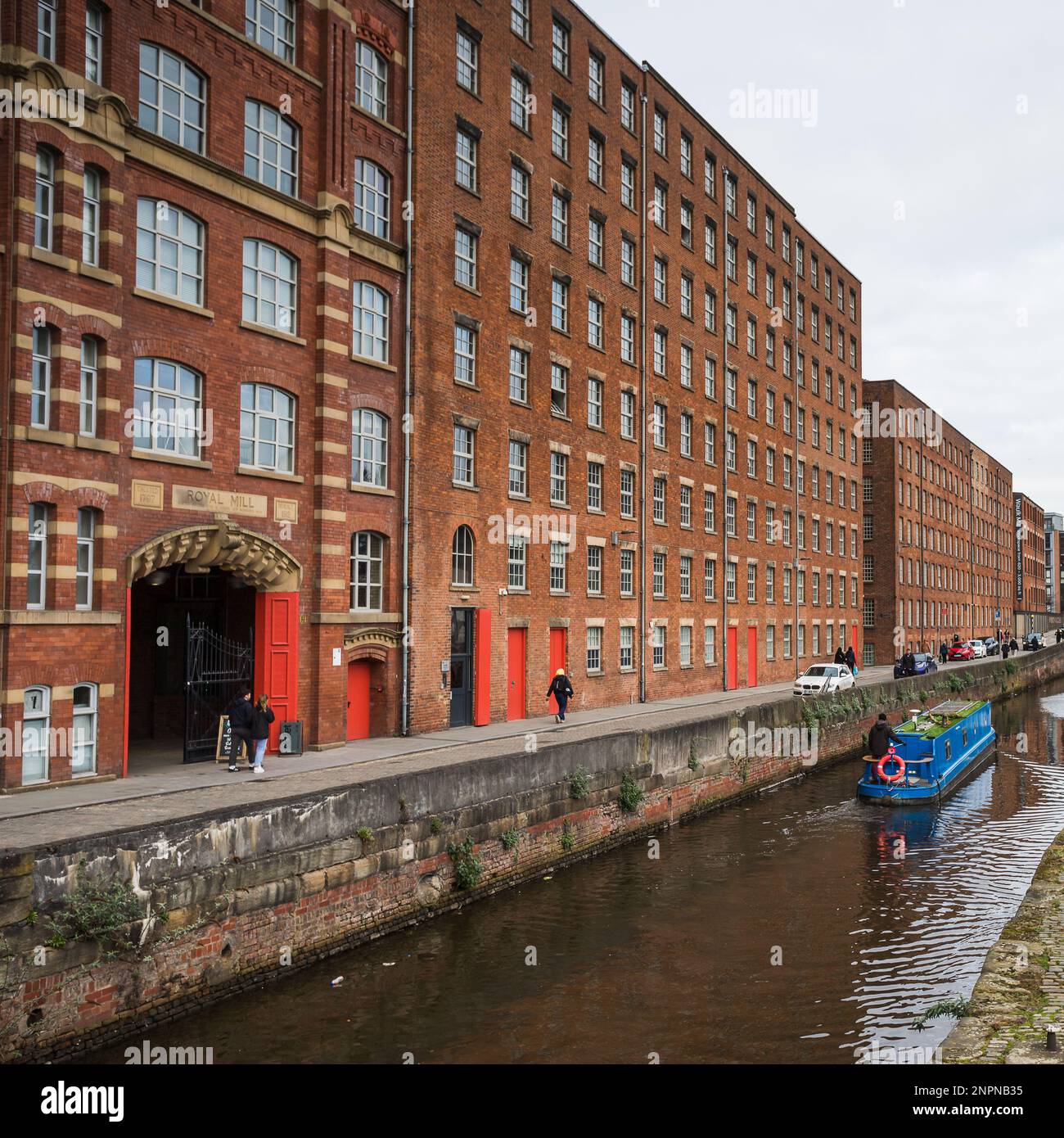 A blue narrow boat contrasts against the traditional red bricks of ...