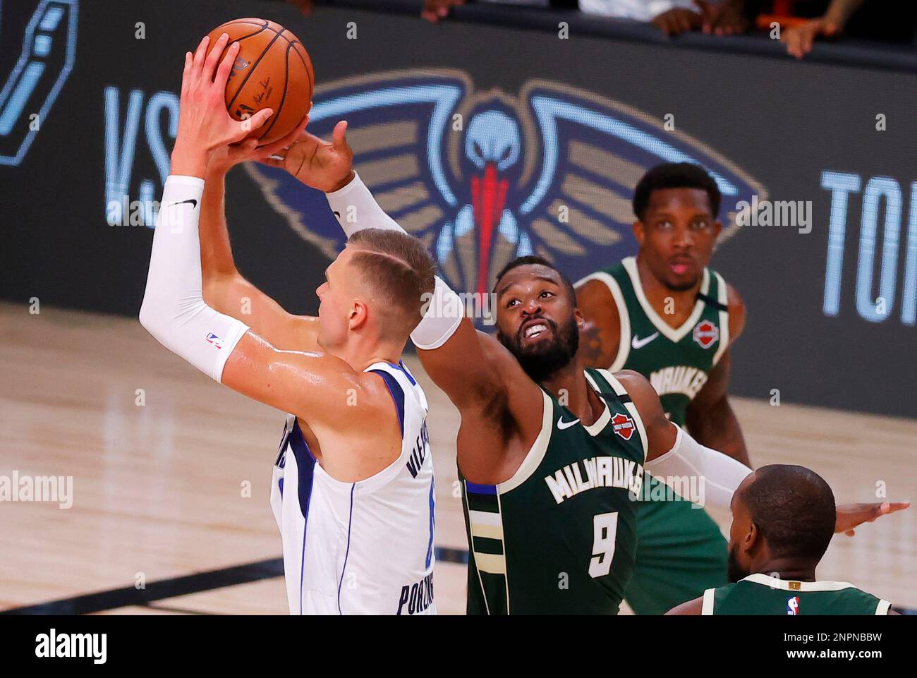 Dallas Mavericks' Kristaps Porzingis, left, attempts to shoot while ...
