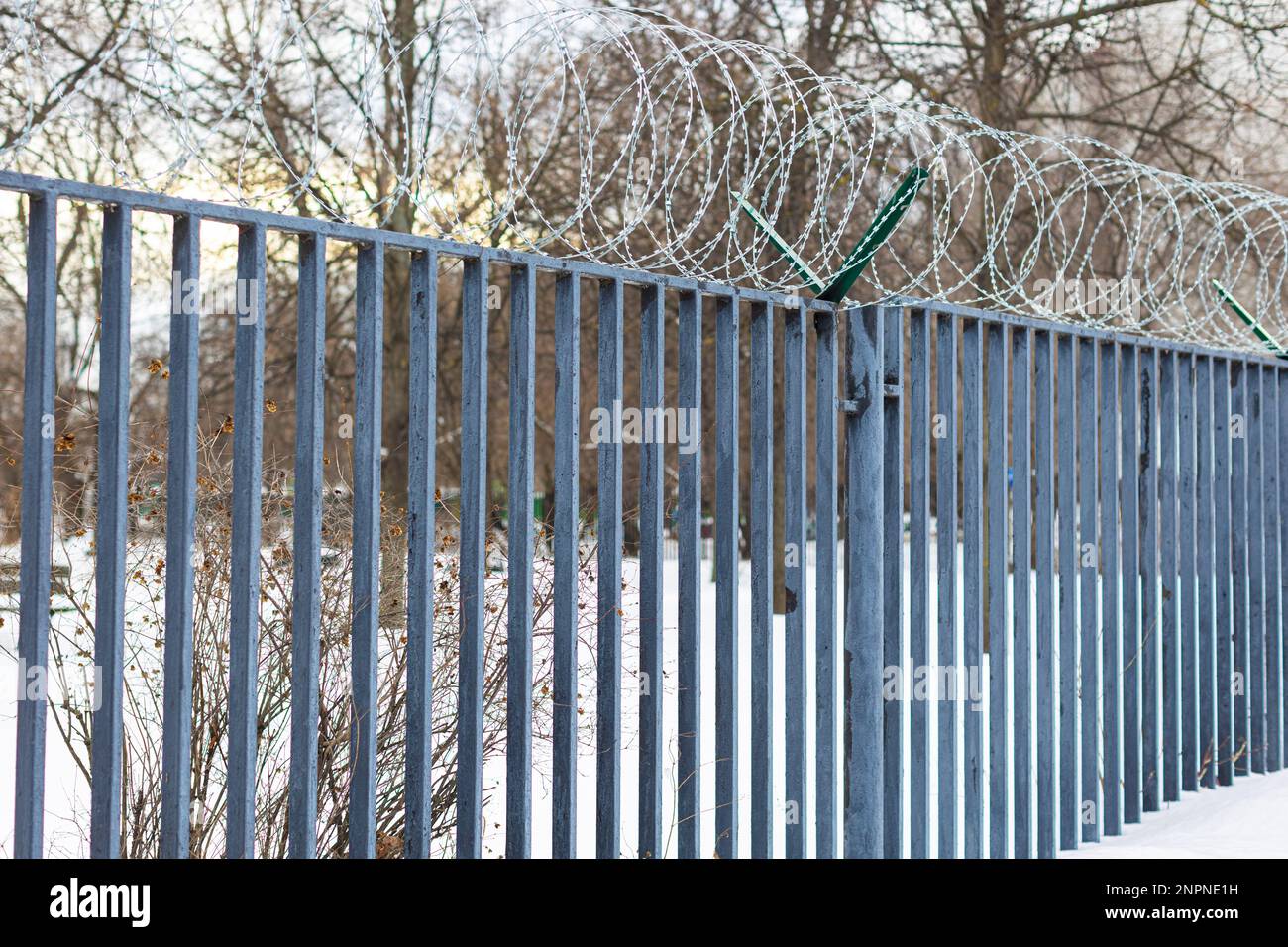street fence with barbed wire in the city. barbed wire fence. protected ...
