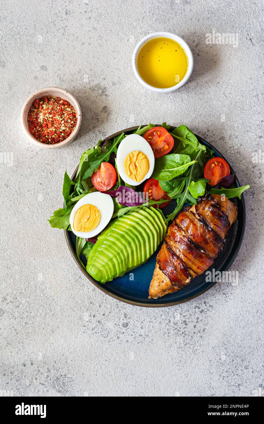 Plate with baked chicken fillet with bacon, fresh vegetables, salad ...