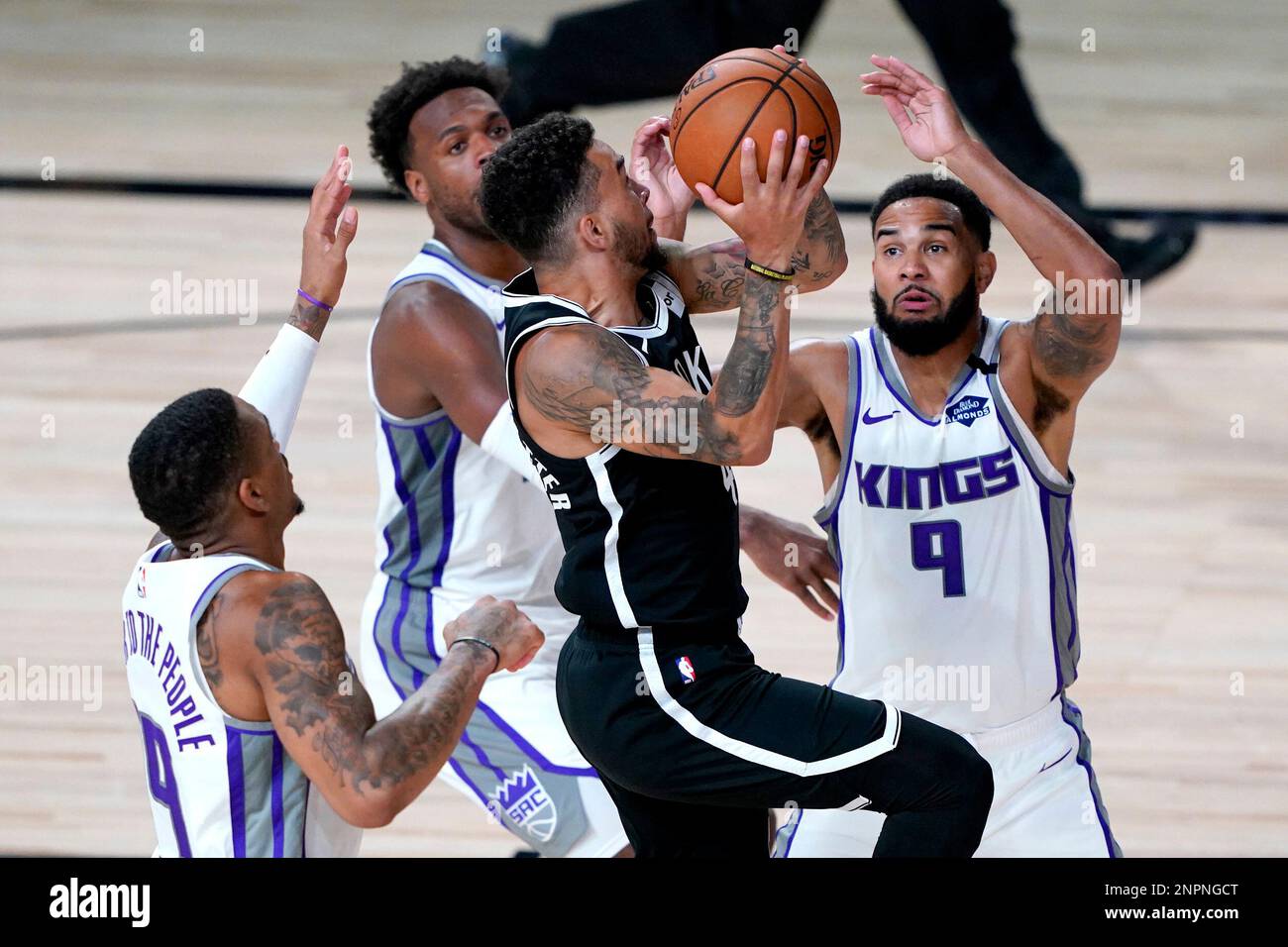 Brooklyn Nets' Chris Chiozza, center, goes up for a shot against ...