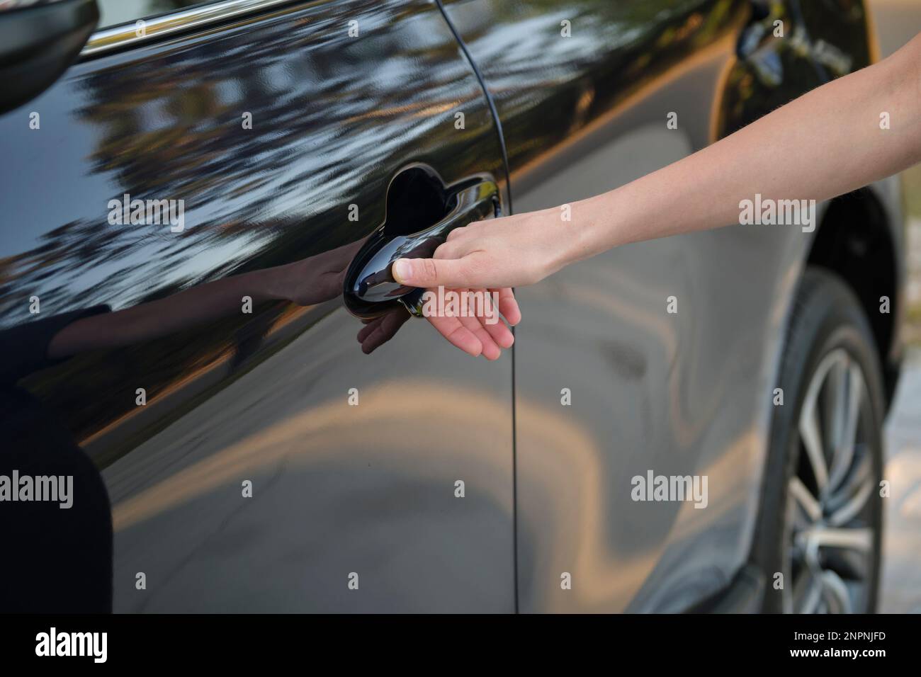 Closeup of driver hand opening car front door with touch ID finger ...