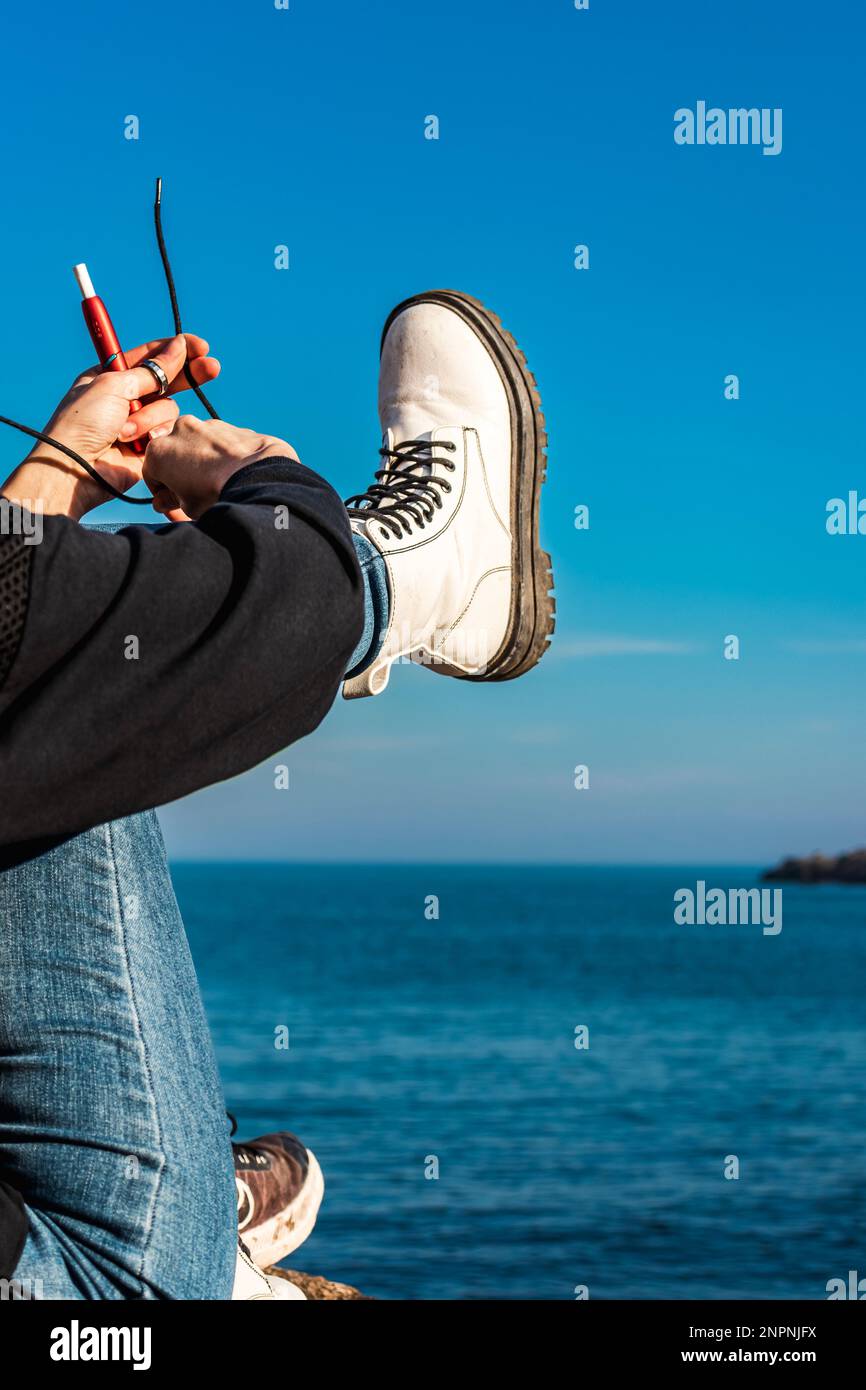 Blue jeand white shoes by the seaside Stock Photo - Alamy