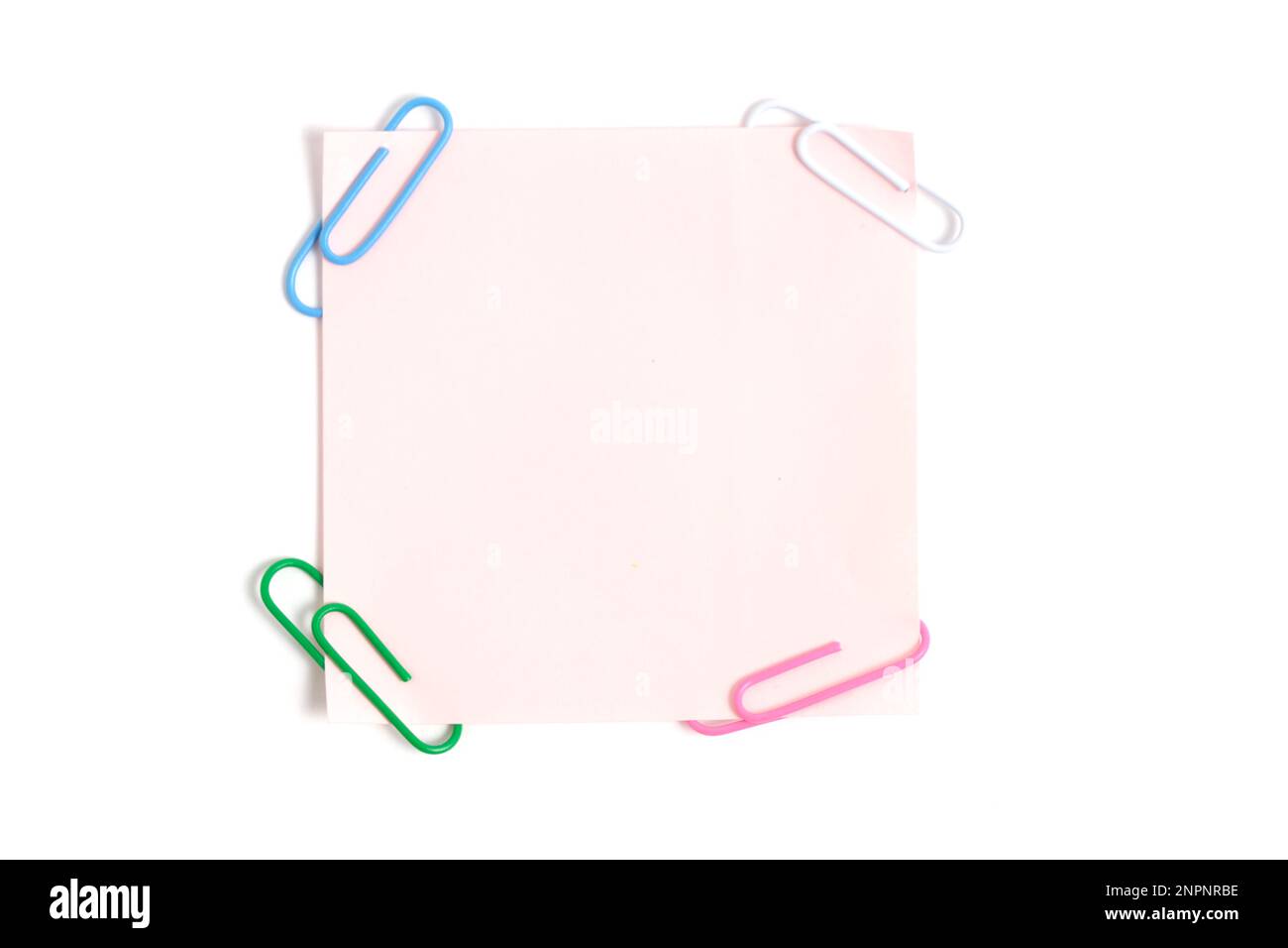 Pink paper sticker for written notes and paper clips on a white ...