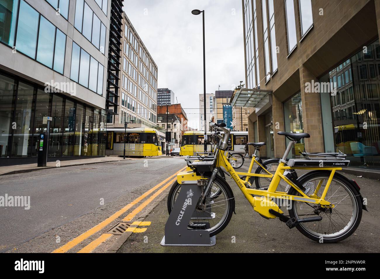 Yellow bicycles lined up on a street in Manchester for hire seen next ...
