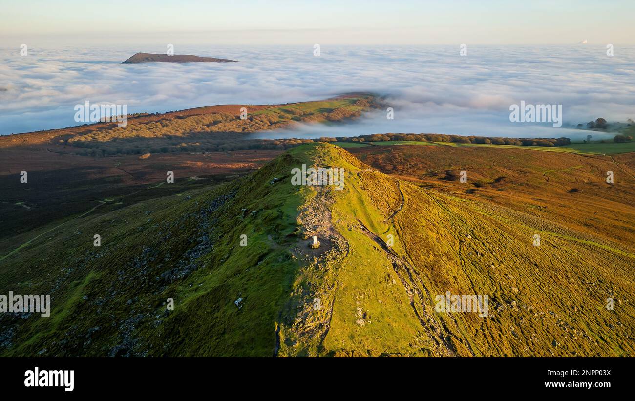 Aerial view of a mountain peak above a sea of fog in a temperature ...