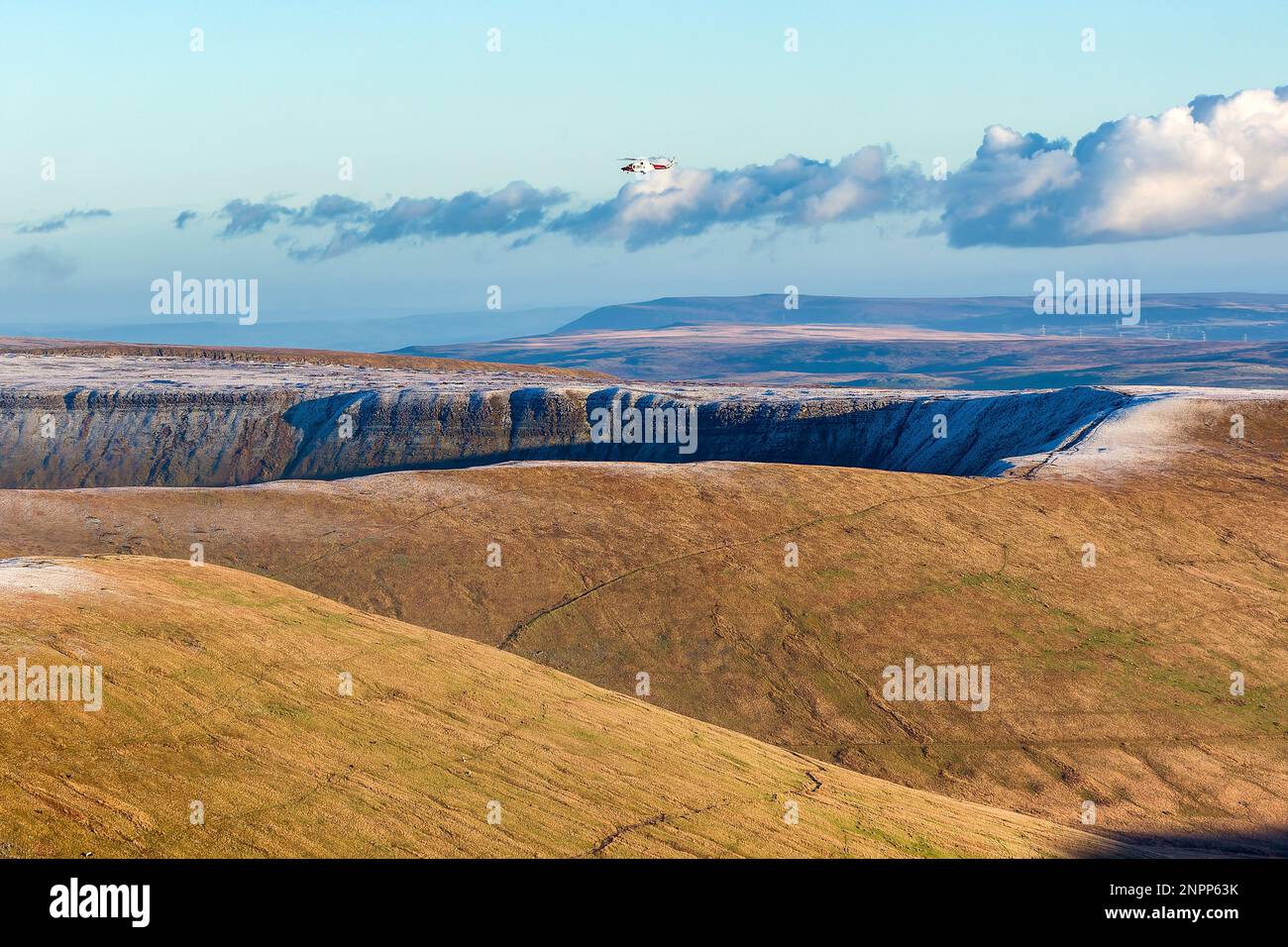 A search and rescue helicopter over snow dusted hillsides (Brecon ...