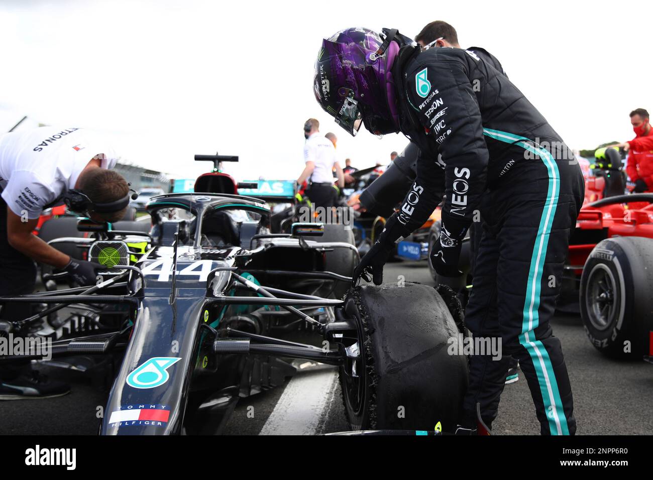 Mercedes driver Lewis Hamilton of Britain inspects puncture on his car ...