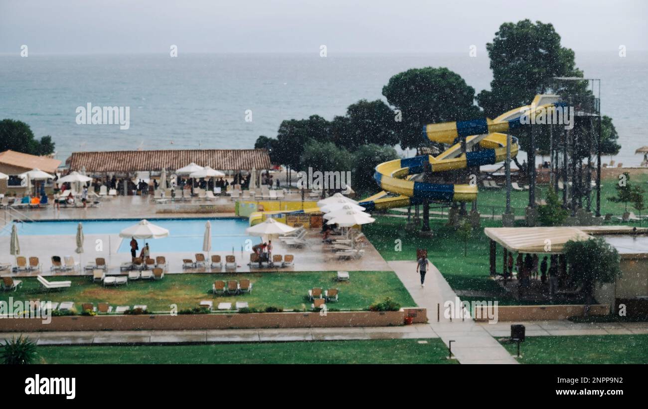 Blurred Shot Of Hotel Area With Pool And Water Slide During Rain ...