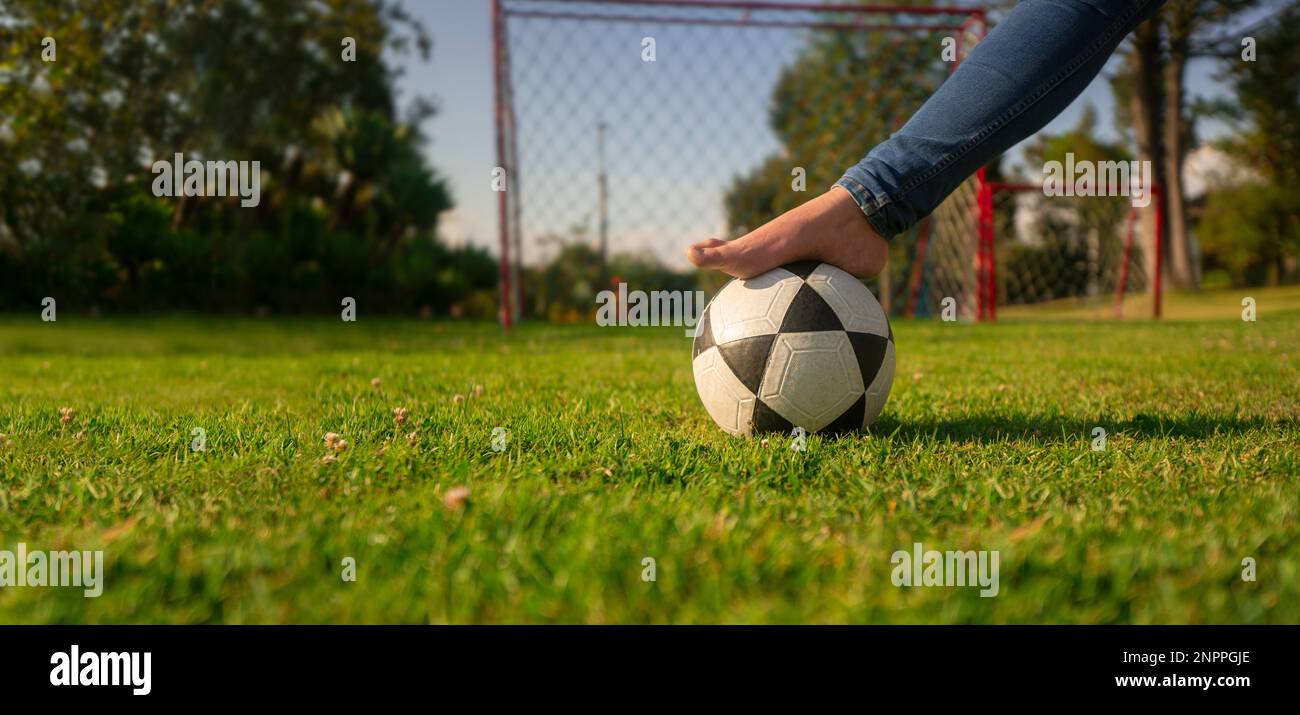 Close up on the leg of a woman in blue pants, barefoot in the middle of ...