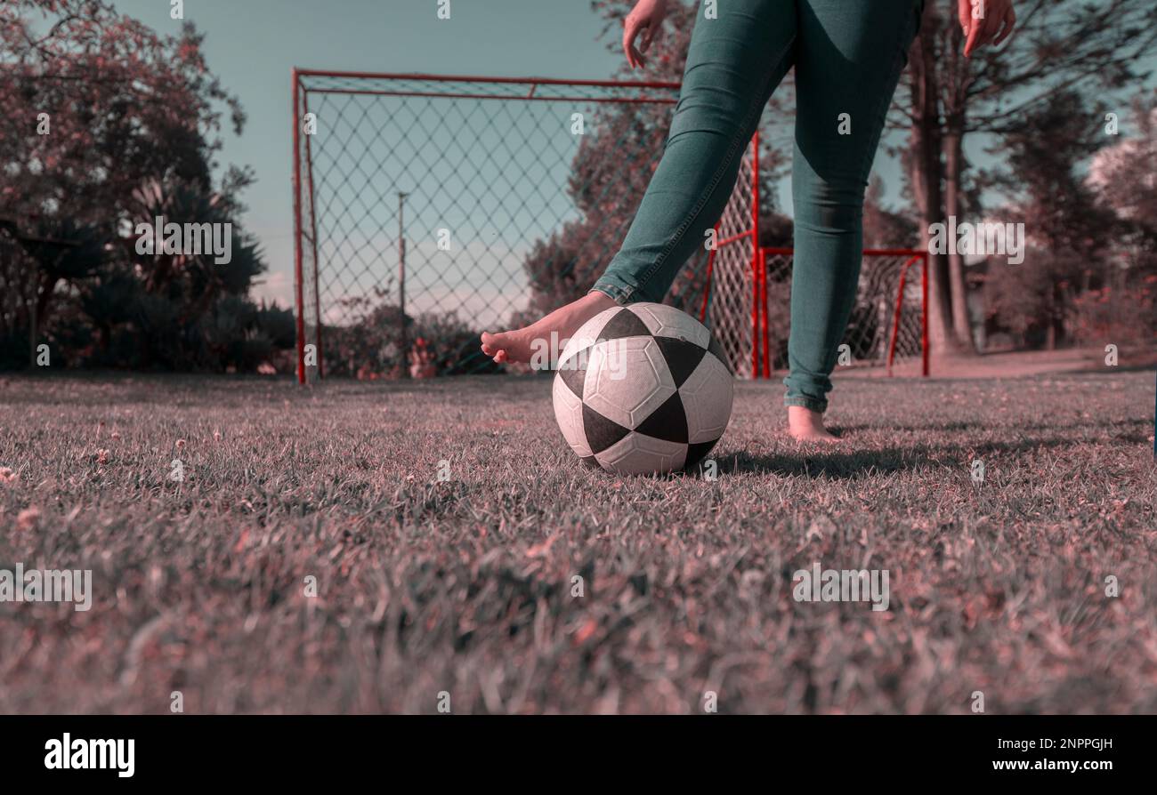 Close up on legs of woman in blue pants, barefoot in middle of park ...