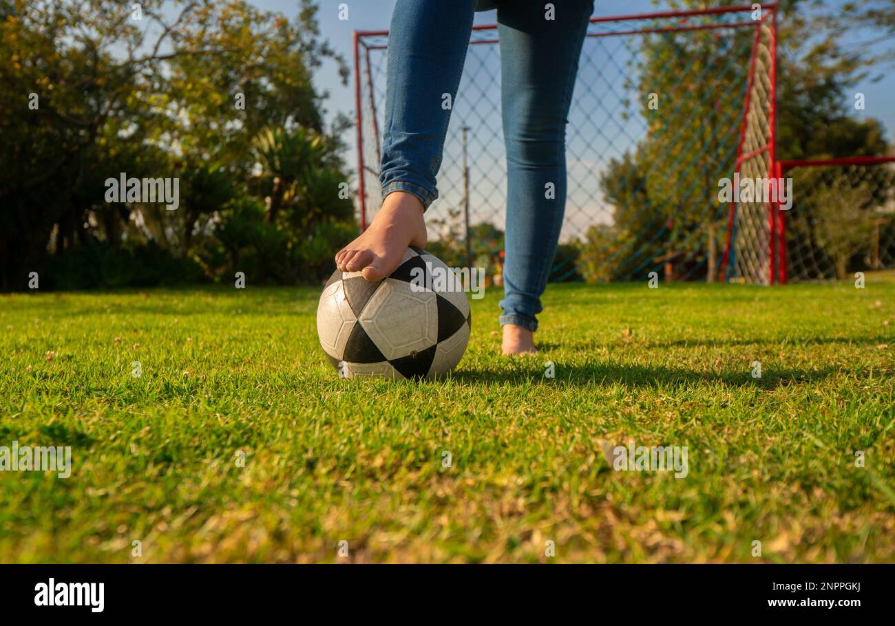 Close up on the legs of a woman in blue pants, barefoot in the middle ...