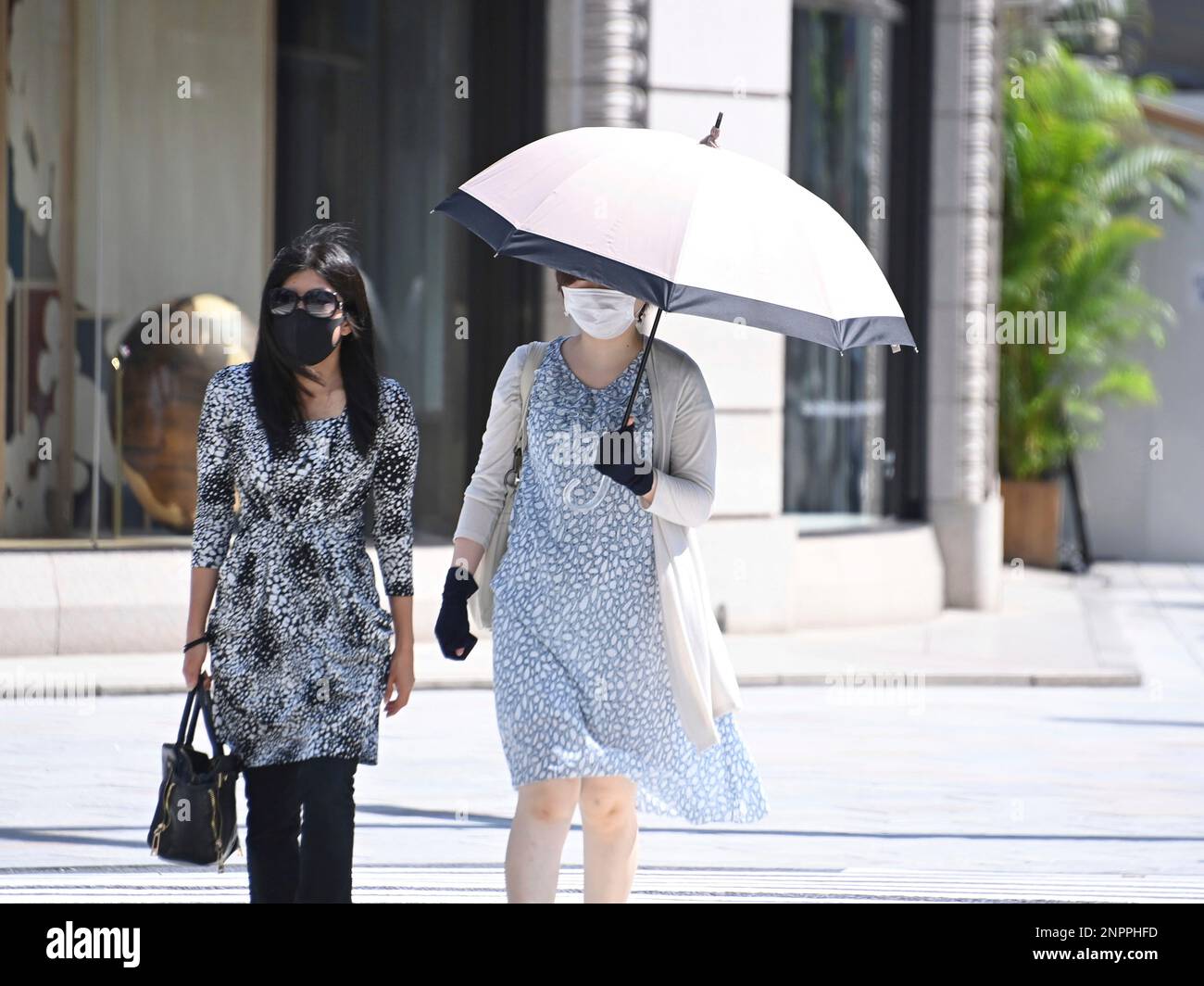 People walk in strong sunshine at Ginza district, Tokyo on Aug. 1, 2020 ...