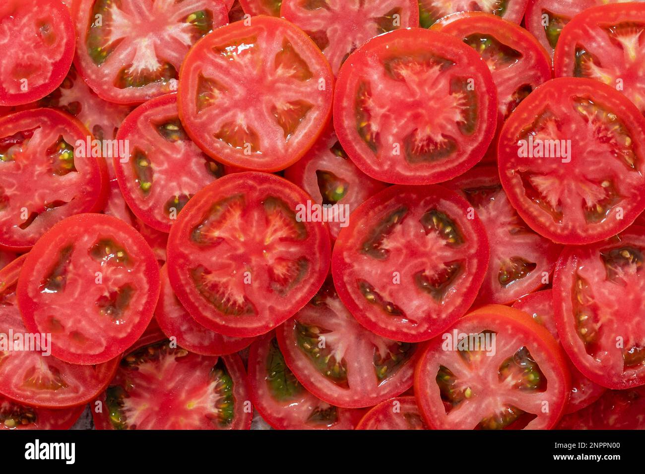 Tomato slices. Natural background with slices of tomato Stock Photo - Alamy