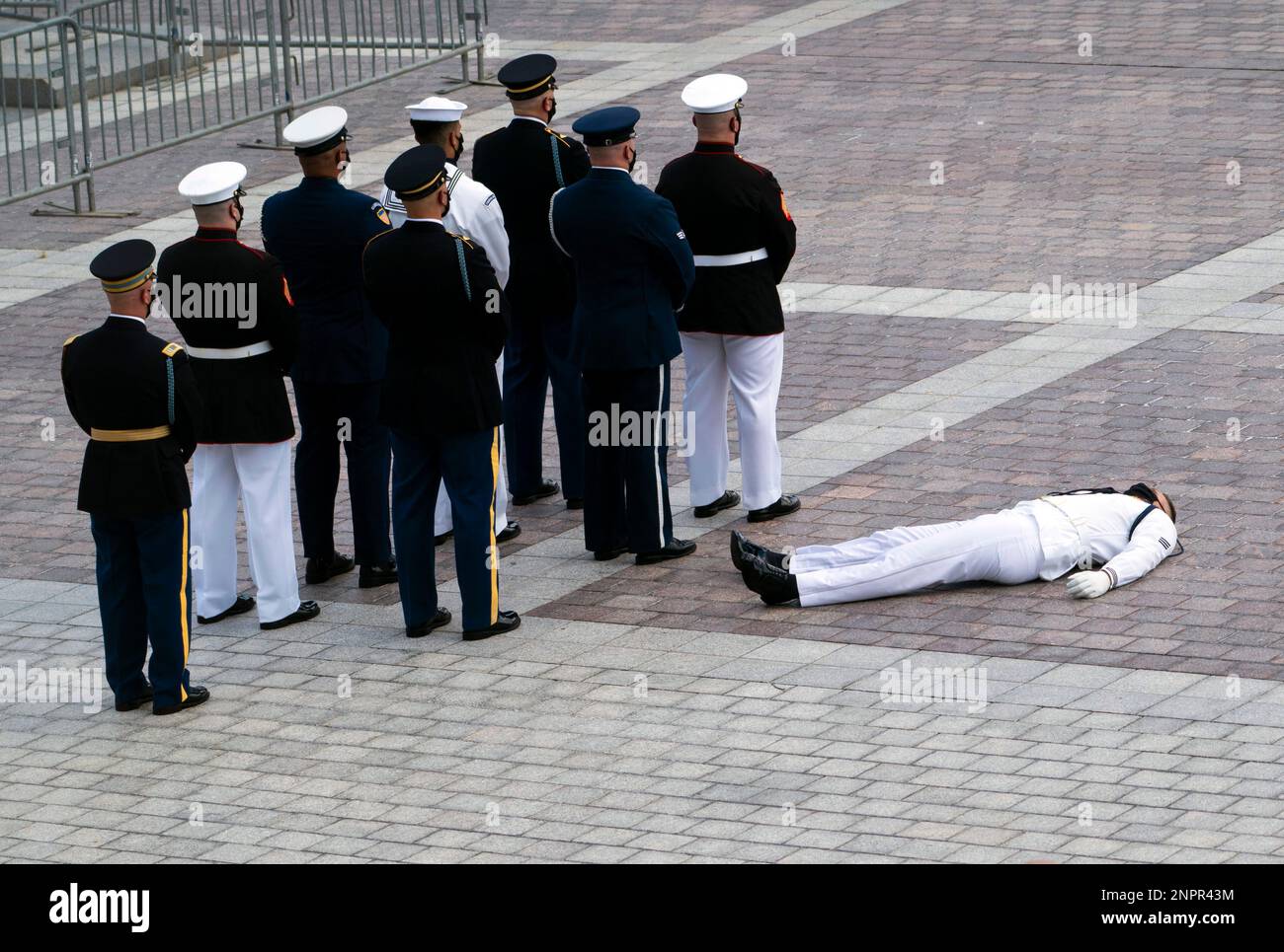 A member of the joint services military honor guard lies on the ground ...
