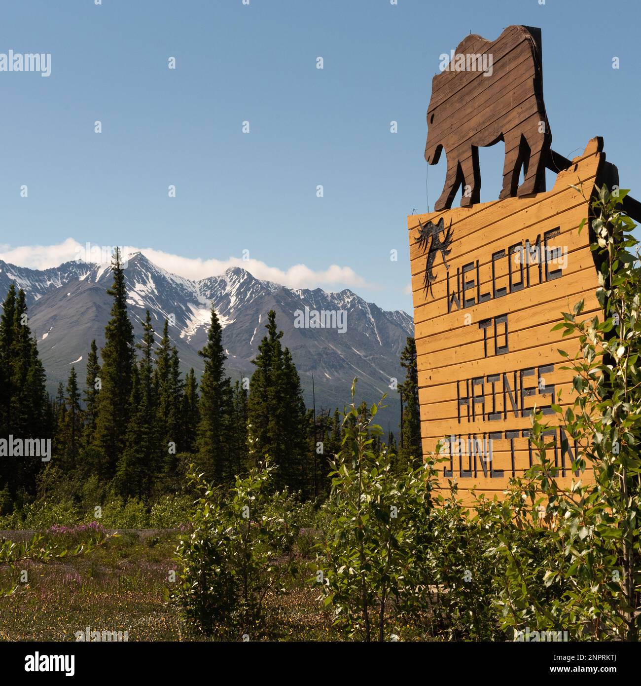 Welcome to Haines Junction sign taken in spring time with stunning snow ...
