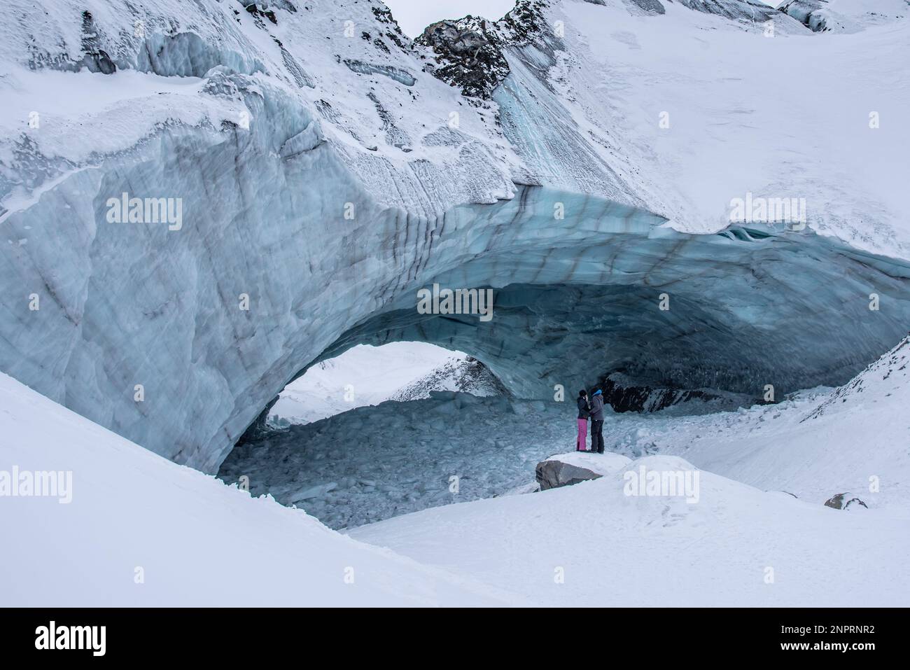 Couple, man & woman, standing in front of amazing ice cave in Yukon ...