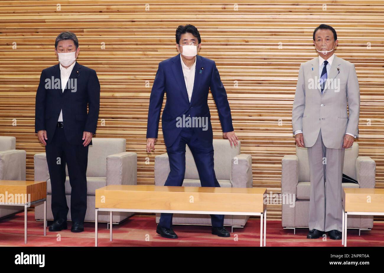 Japan's Prime Minister Shinzo Abe (C) wearing a face mask (abenomask ...