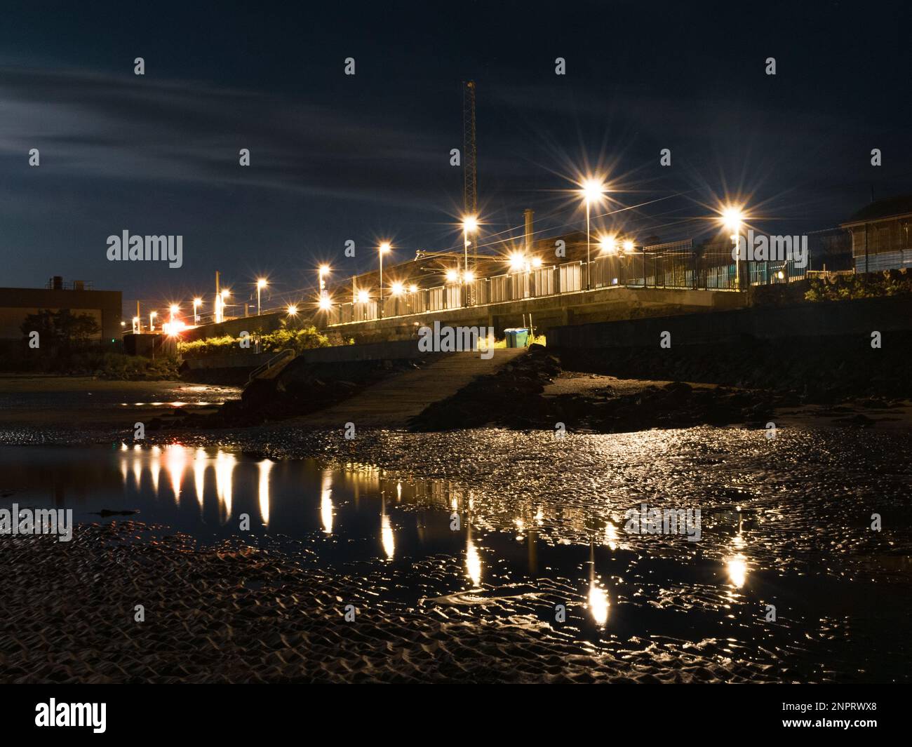 Howth station night reflections at Claremont Beach Stock Photo - Alamy