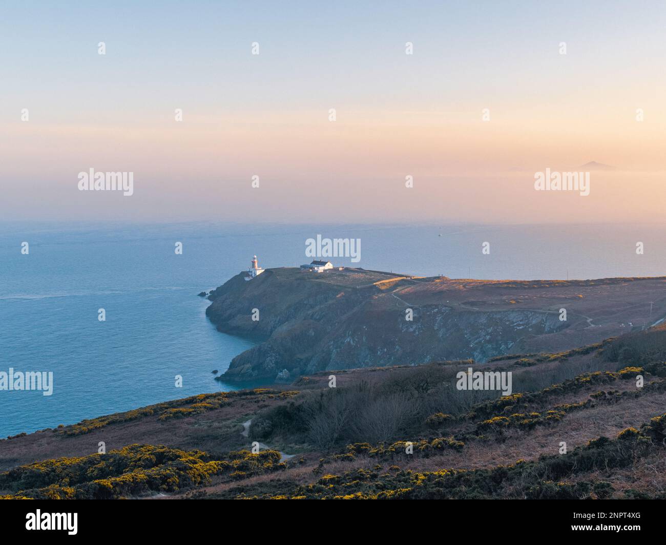 Misty evening light at the Baily Lighthouse at the Howth Cliff Walk ...