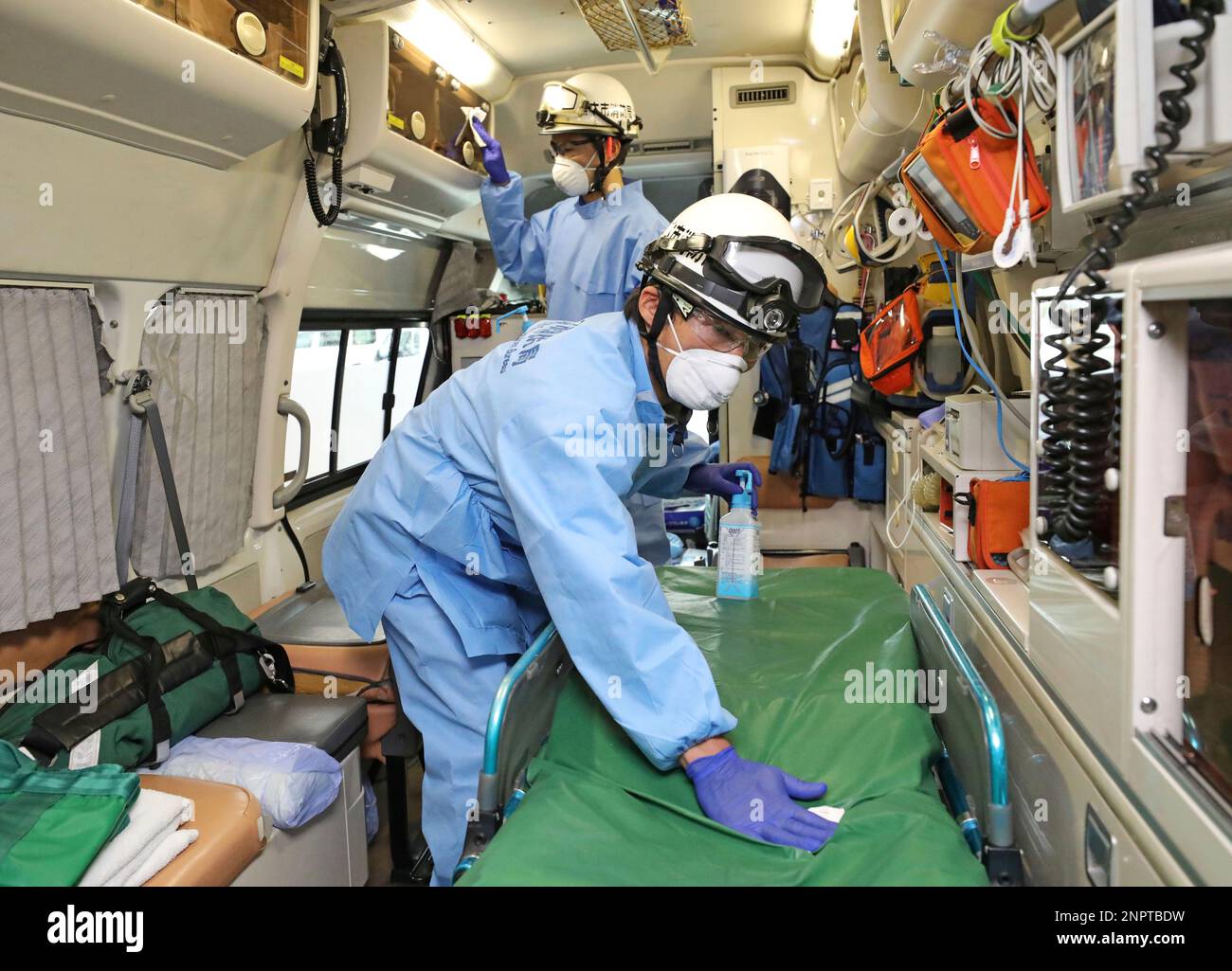 Emergency service workers wearing protectable gears disinfect the ...