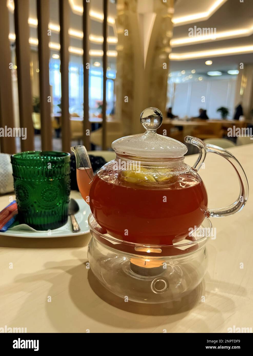 Kettle of fruit tea and a glass in a restaurant Stock Photo - Alamy