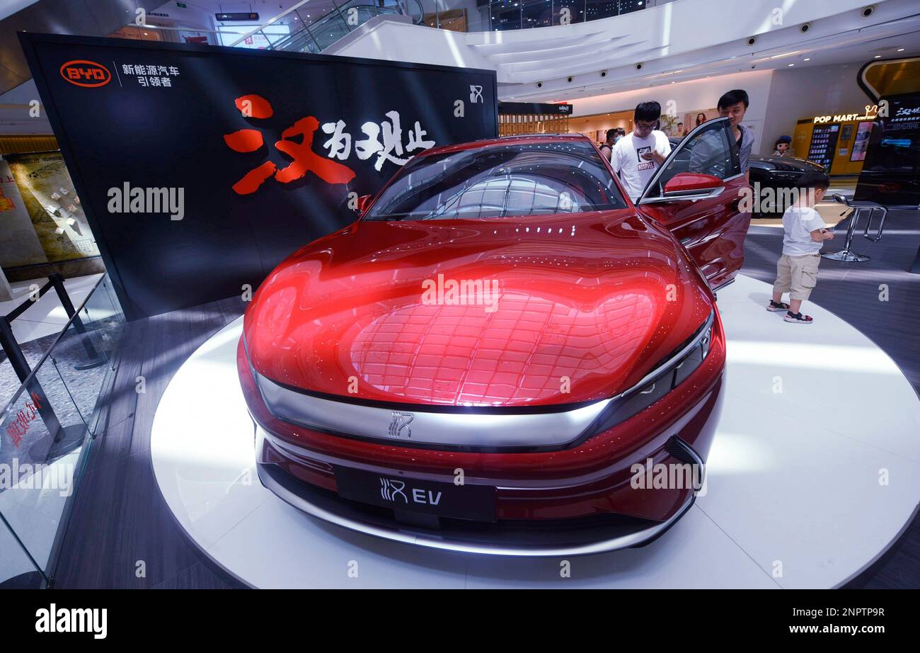 People check out a BYD Han electric car in a shopping mall in Hangzhou ...