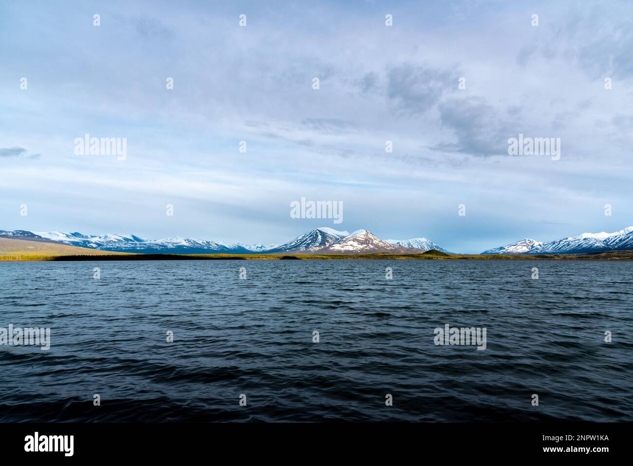 Northern Canadian views in spring time with clouds and snow capped ...