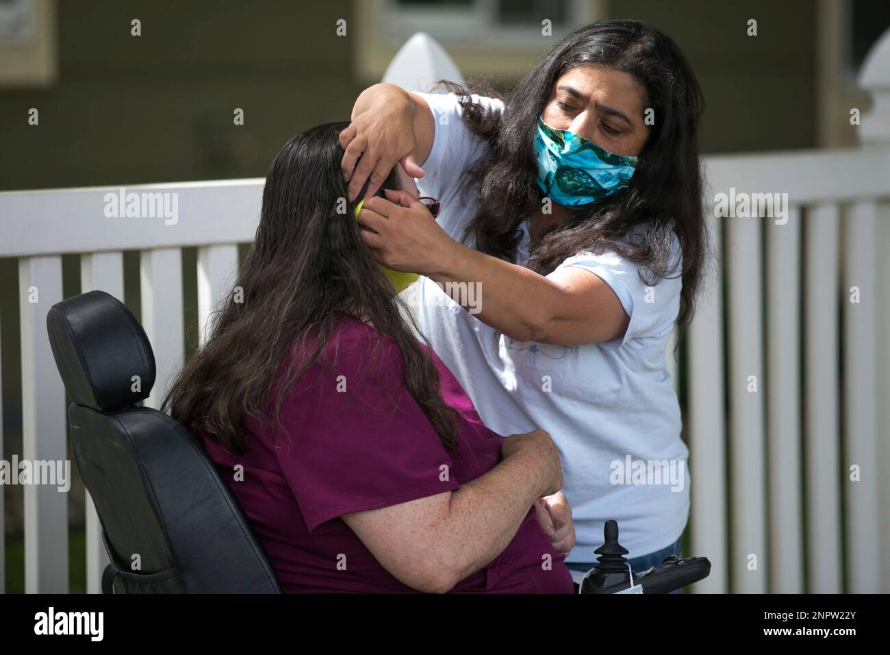 Lupe Anderson, a local caregiver, helps Christine Laframboise, a ...